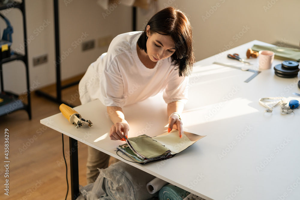 Tailor choose cloth material while working in workshop. Sewer or ...