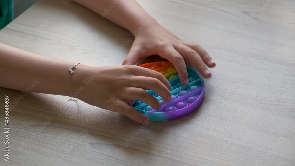 Close up shot of kids fingers on pop it fidget toy. Instrument for ...