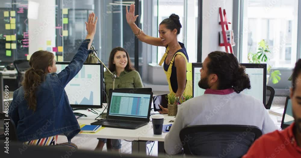 Diverse group of work colleagues giving high five and smiling Stock ...