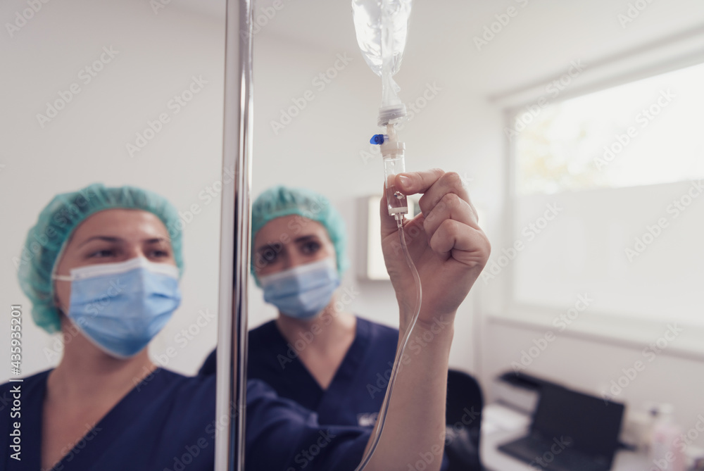 General practitioner holding intravenous drip infusion. Doctor handling ...