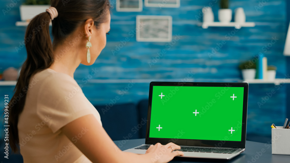 Business woman looking at laptop display with mock up green screen ...