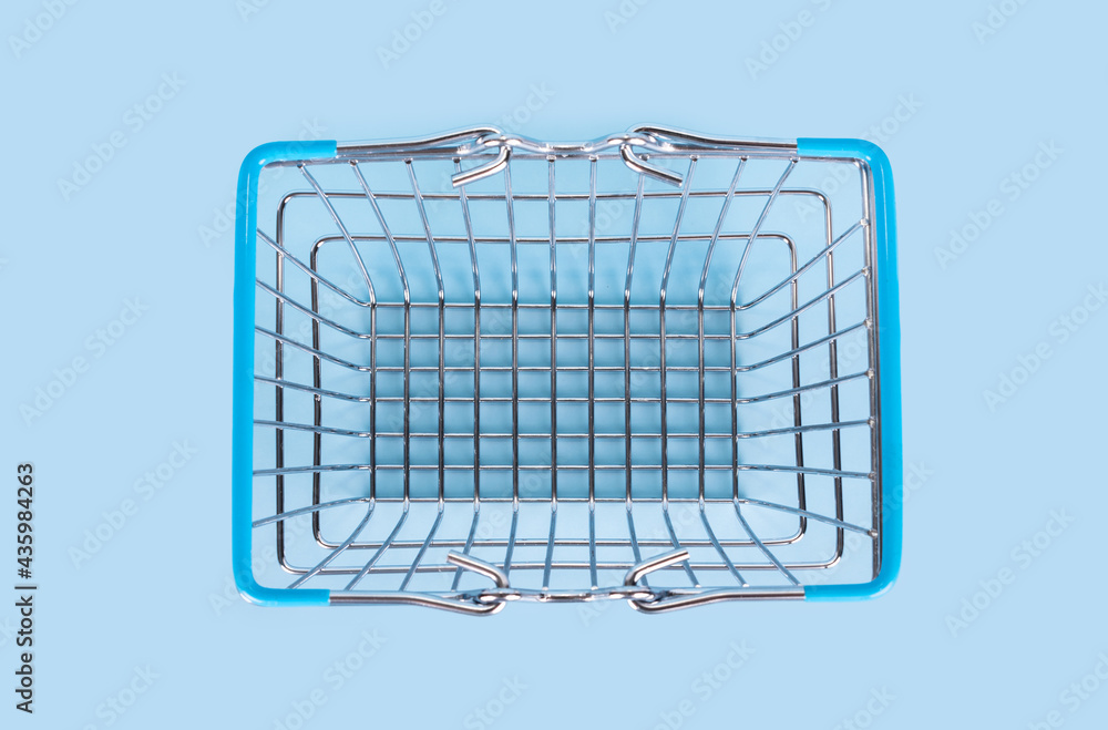 Top view of supermarket shopping basket on light blue background. Empty ...