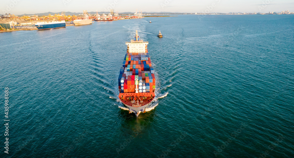Aerial in front view of cargo ship with contrail in the ocean sea ship ...