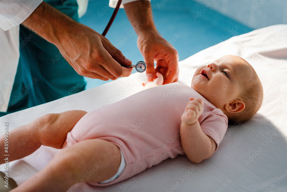 Happy pediatrician doctor with baby checking possible heart defect ...