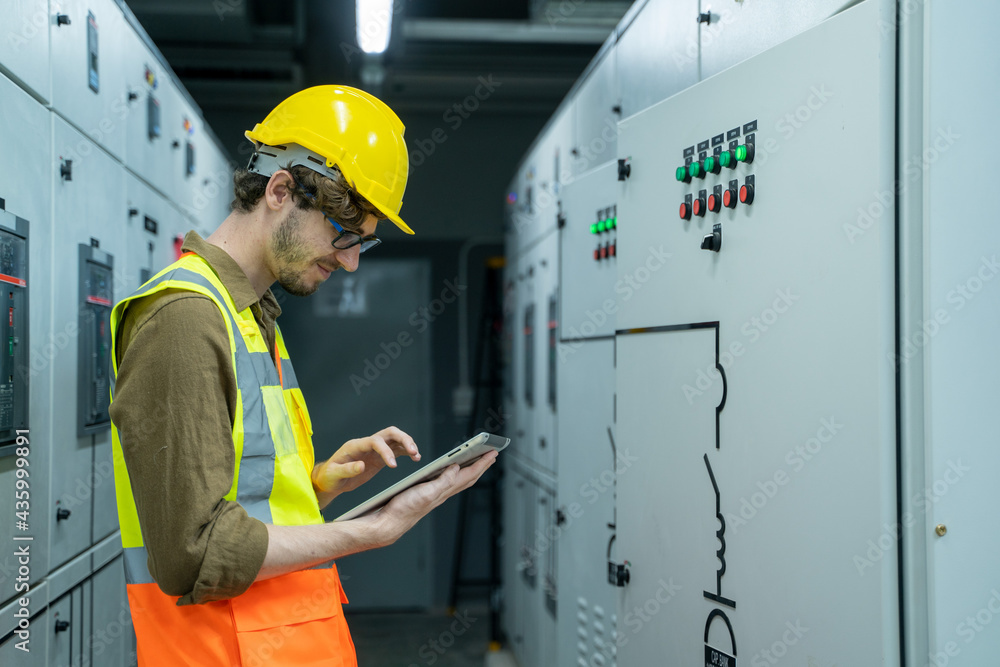 Electrical engineers use digital tablet checking in power plant control ...