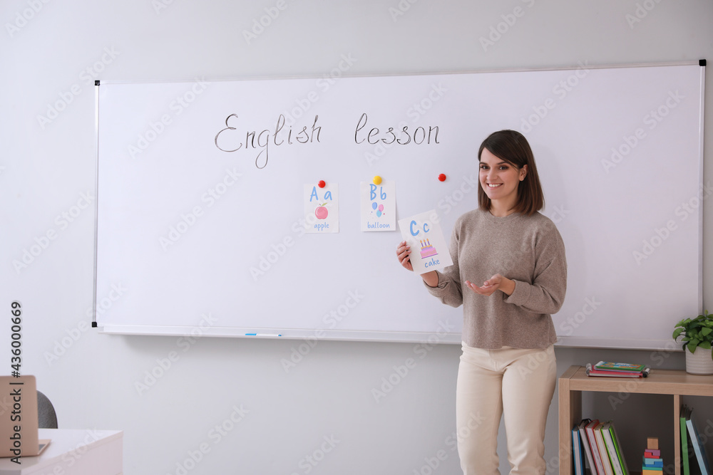 Happy female English teacher giving lesson indoors. Early childhood ...