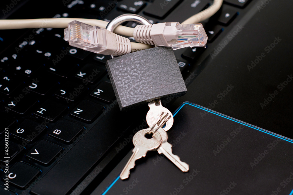 internet cable passing through a closed iron lock with keys on a laptop ...