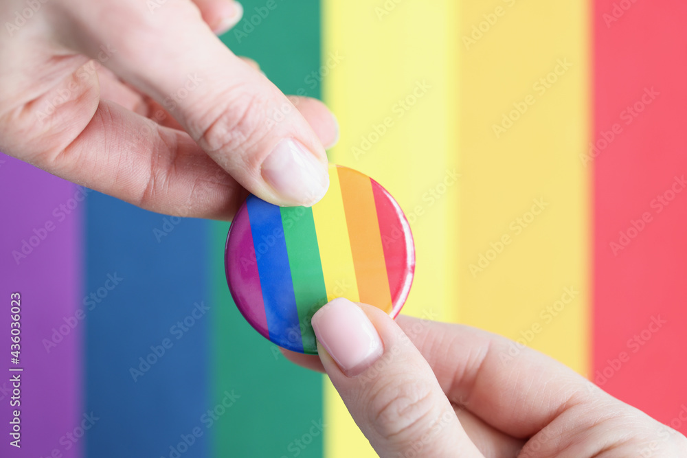 Two people hold lgbt sign against background of flag of sexual ...