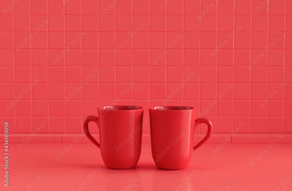 Two Red porcelain coffee cups side by side on single red color ...
