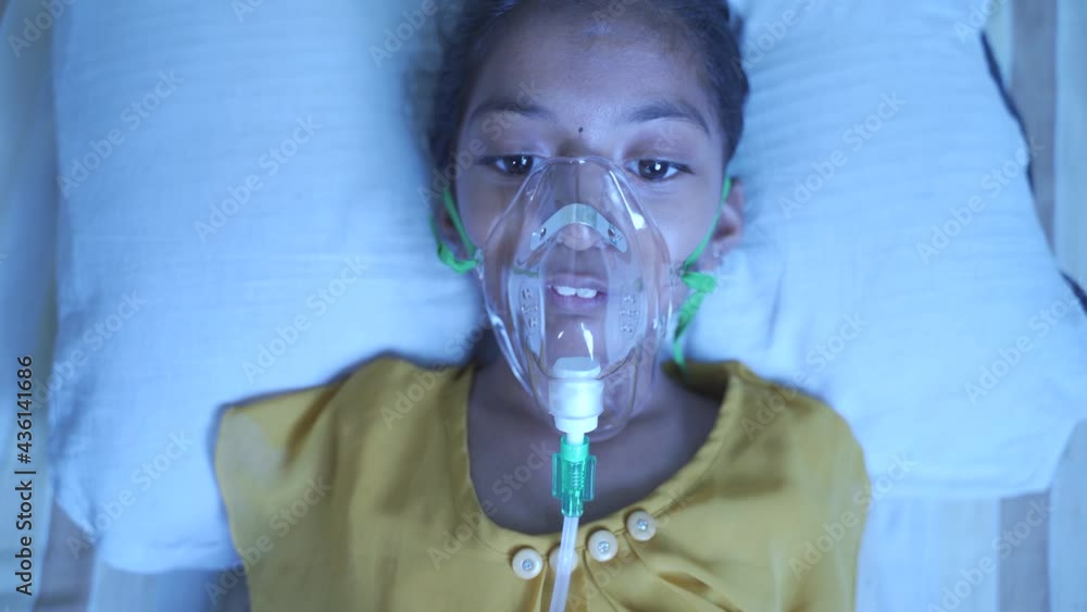 Close up top view of young kid breathing on ventilator oxygen mask due ...