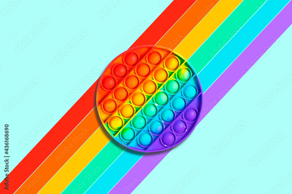 Round rainbow kids toy antistress pop it or simple dimple on a blue ...