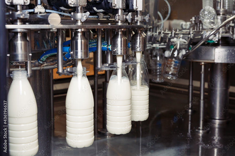 filling milk in to plastic bottles at the factory. equipment at the ...