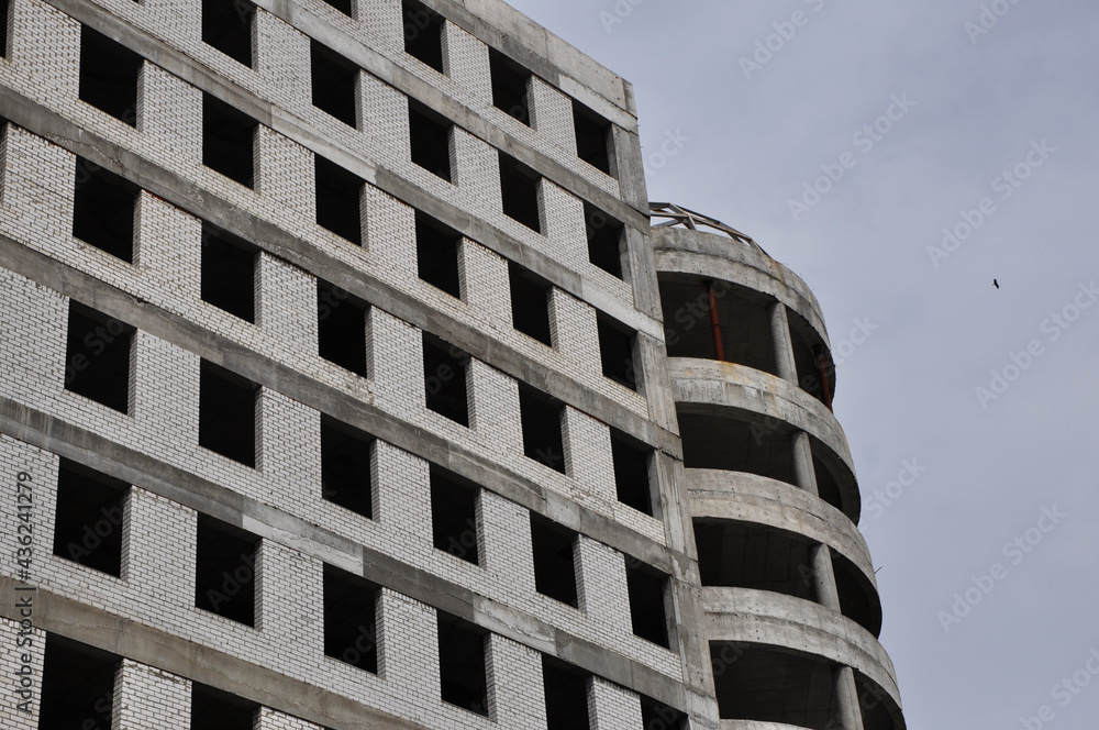 Rounded corner part of constructed building against the sky, with gray ...