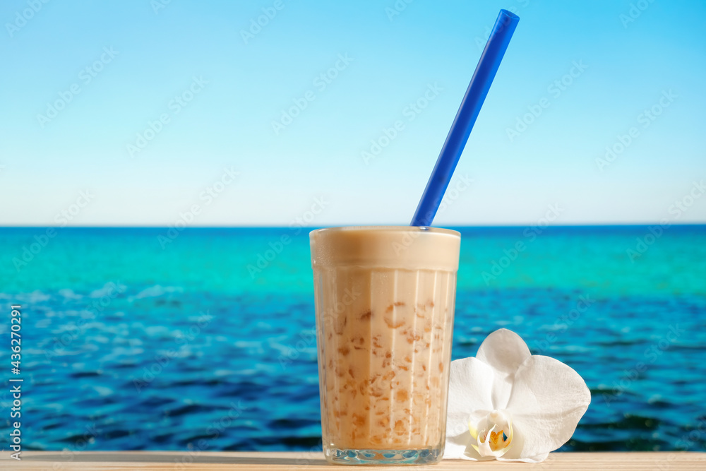 Glass of bubble tea. Milk boba tea with tapioca pearls, blue sea on ...