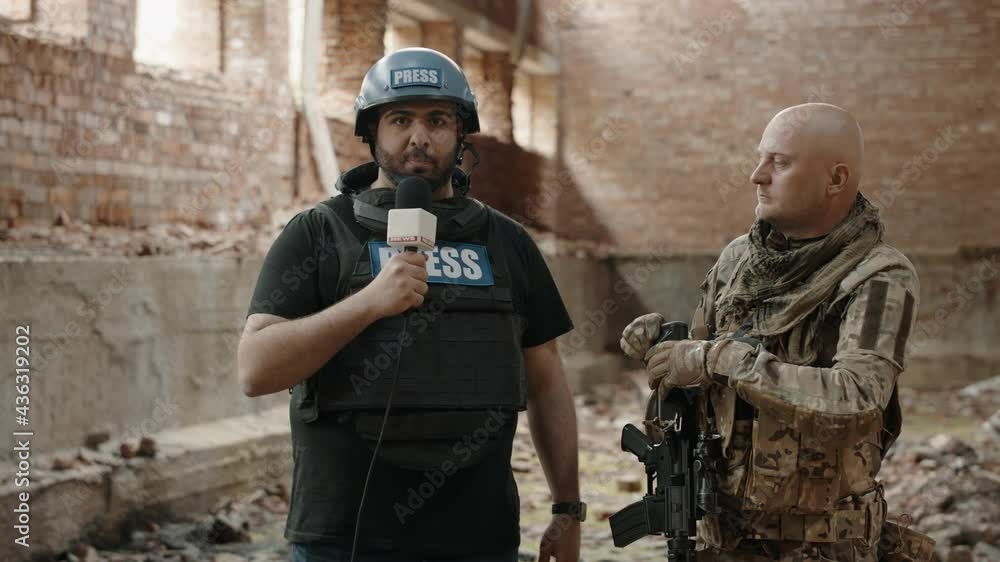 POV War journalist correspondent wearing bulletproof vest and helmet reporting live near ...