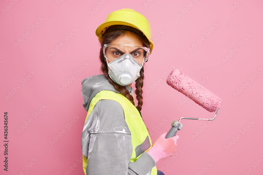 Indoor shot of angry professional female construction worker renovates ...