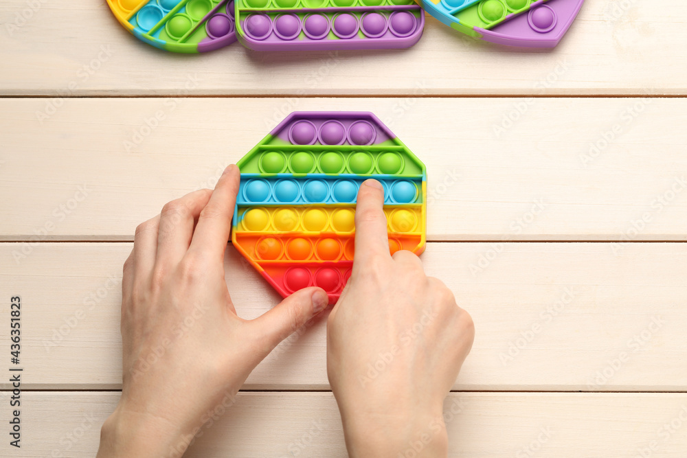 Woman using pop it fidget toy at white wooden table, top view Stock ...