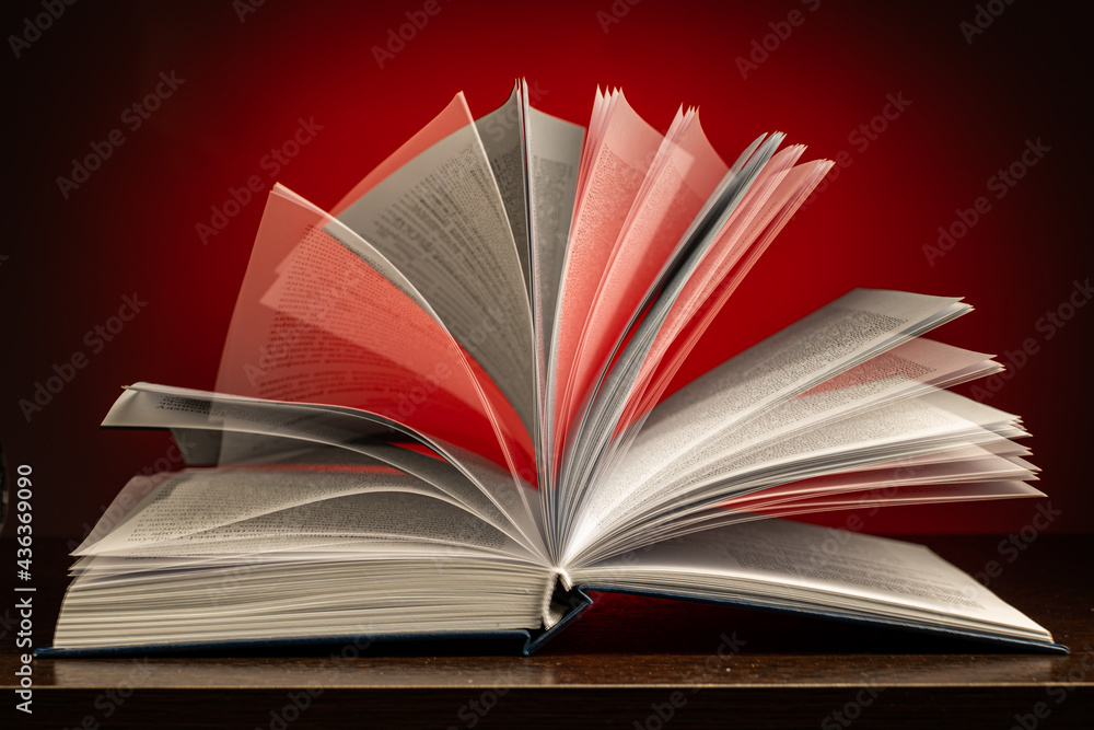 flipping through the pages of an open book on a red background Stock ...