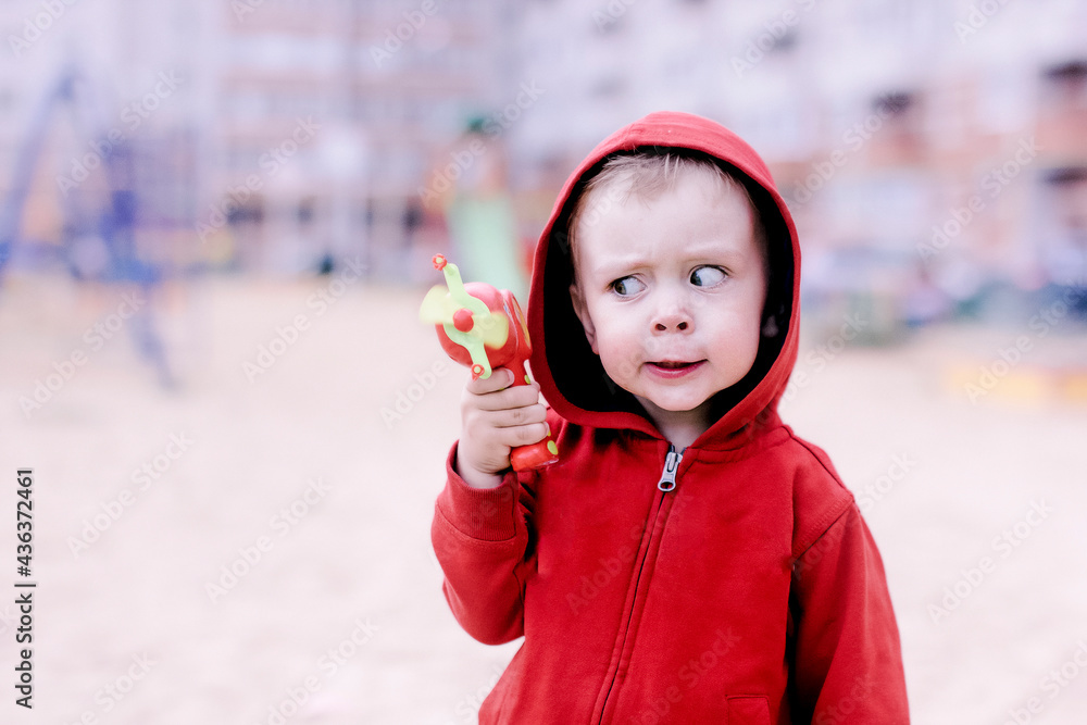 Cute kid with a toy gun on the playground having fun. Free space for ...