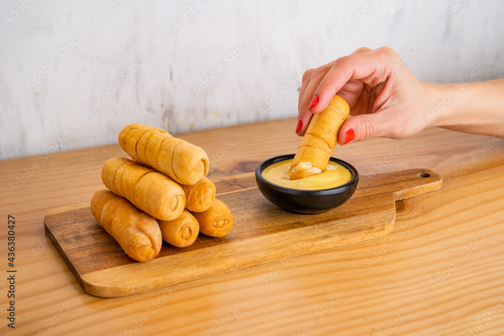 Venezuelan tequenos cheese fingers piled high and hand with tequeno ...