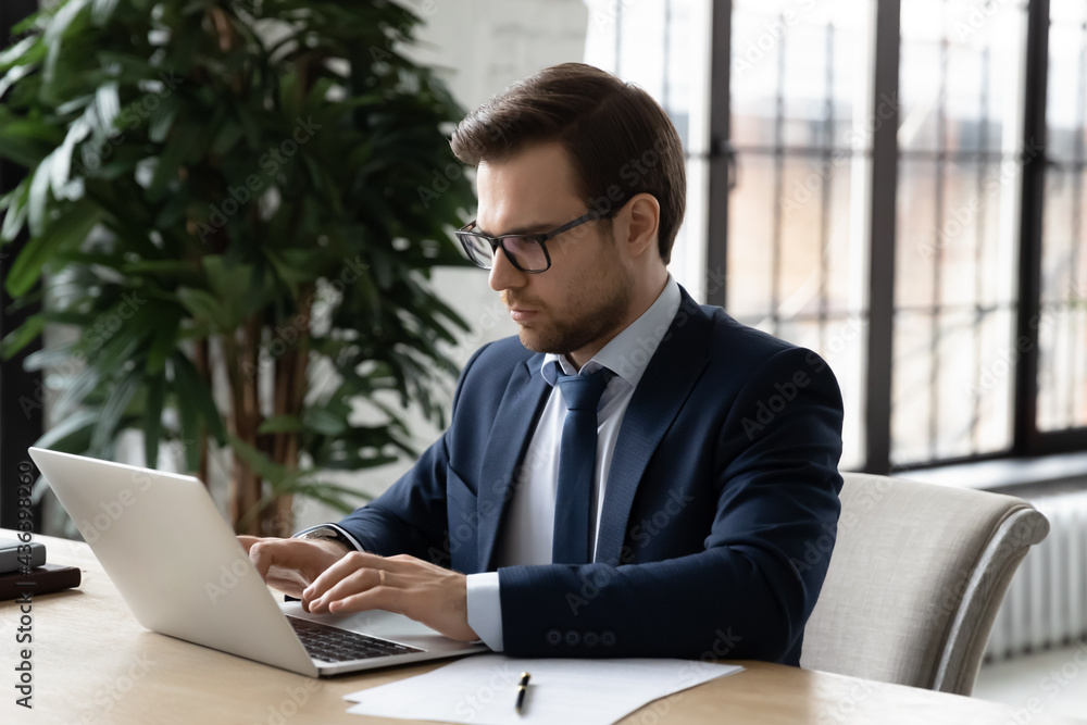 Focused businessman working at computer in office, typing, chatting ...