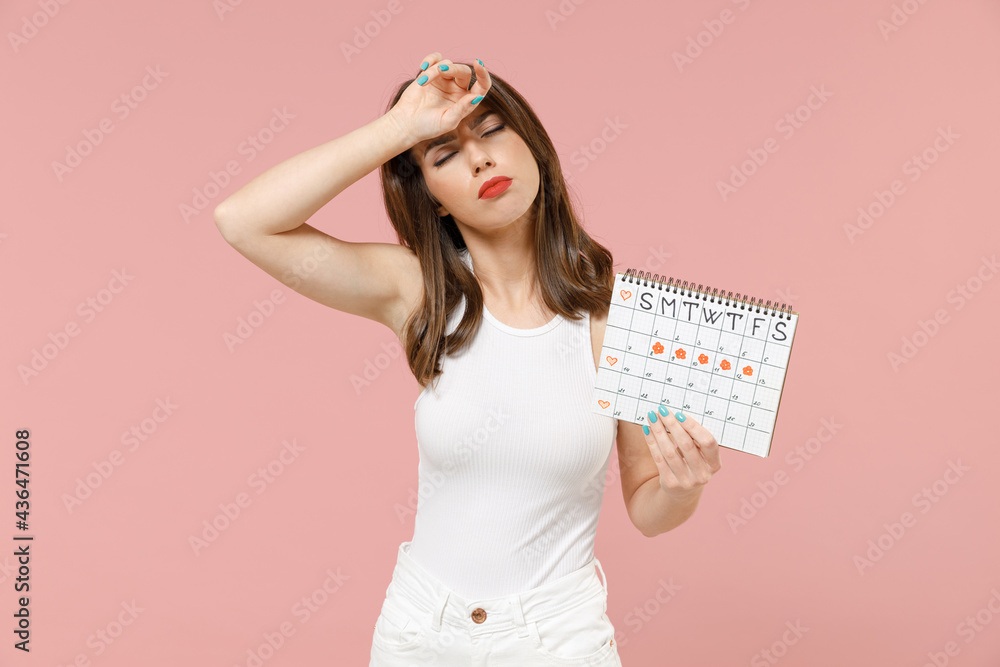 Young woman in white clothes hold female periods calendar for checking ...