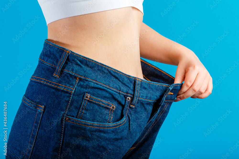 Skinny weight loss woman show flat stomach pulling oversized big blue ...