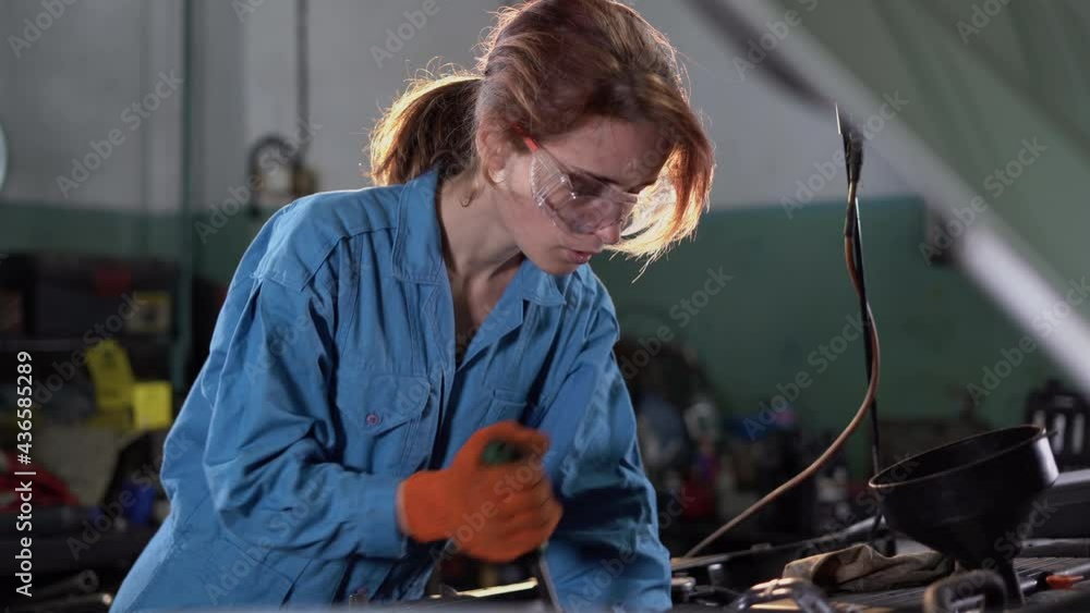 Portrait of a woman mechanic working in a car service. Empowering a ...
