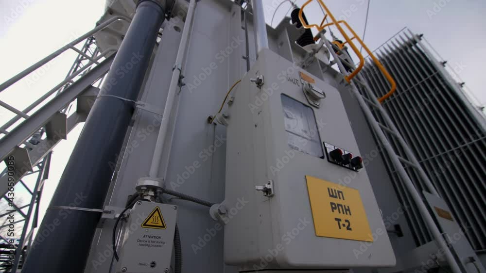 Switchboard with meter and mark on side of large powerful transformer ...