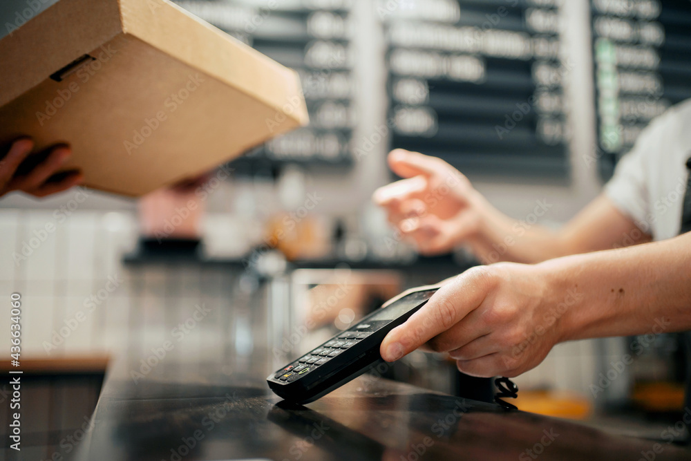 NFC payment in the restaurant. Order pizza delivery home. The employee ...