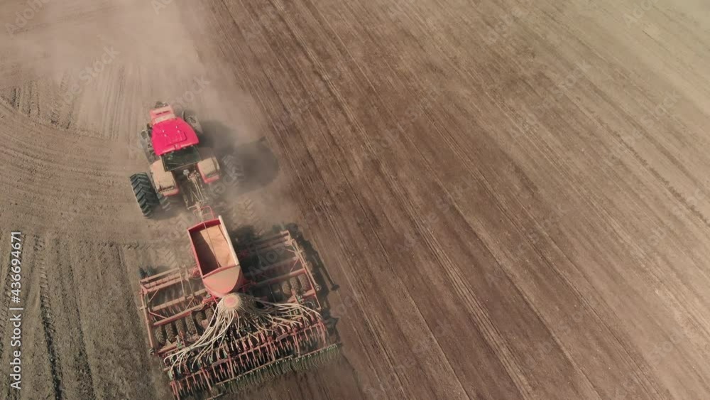Top view of modern tractor with a sowing unit that sows grain crops in ...