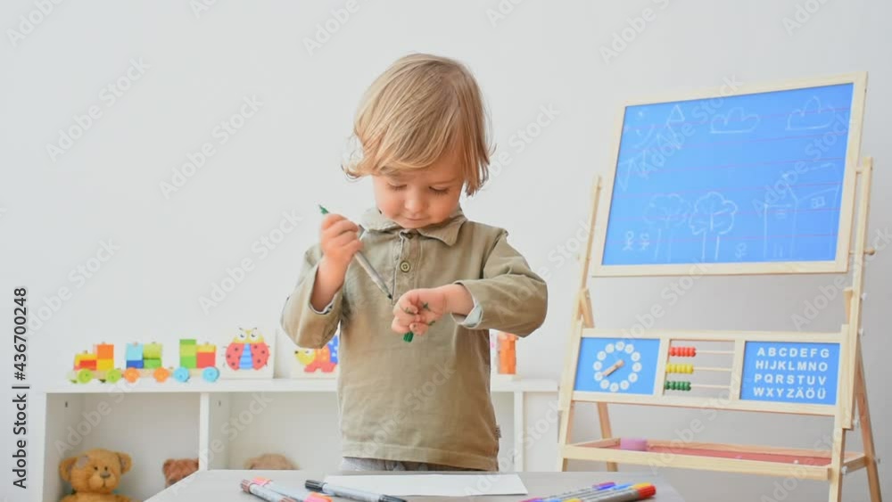 Cute little child having fun at home drawing with colored markers on ...