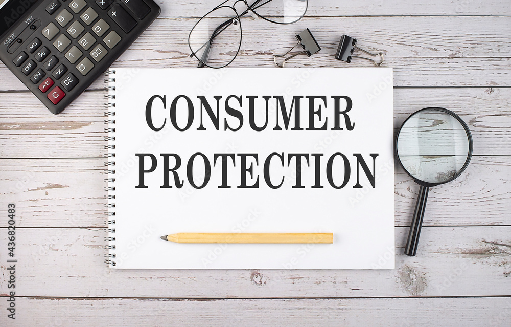 Blank notebook with text CONSUMER PROTECTION on white background with ...