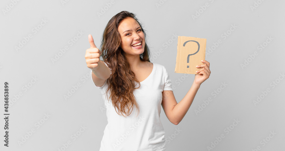 young pretty woman feeling proud,smiling positively with thumbs up and ...