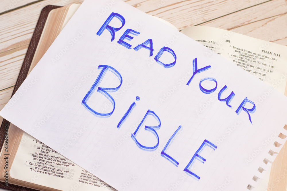 Read your Bible. Christian biblical concept. Handwritten note on opened ...