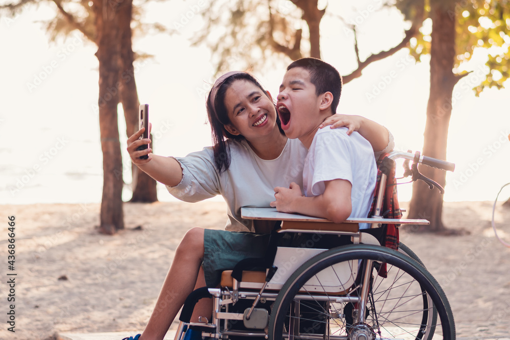 Disabled child on wheelchair is smiling,use smartphone with parent on ...