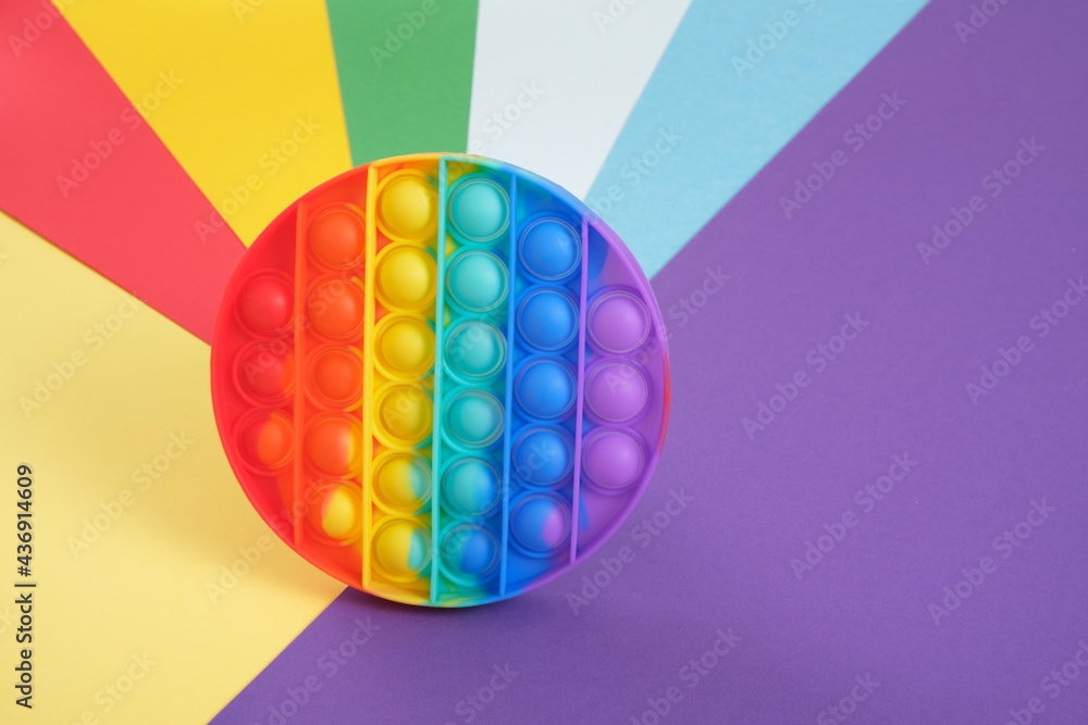toy antistress pop it on a rainbow background, fidget toy, popping ...