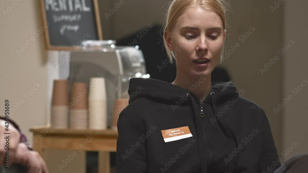 Tilt-up waist-up shot of stressed and hostile young woman with mental ...