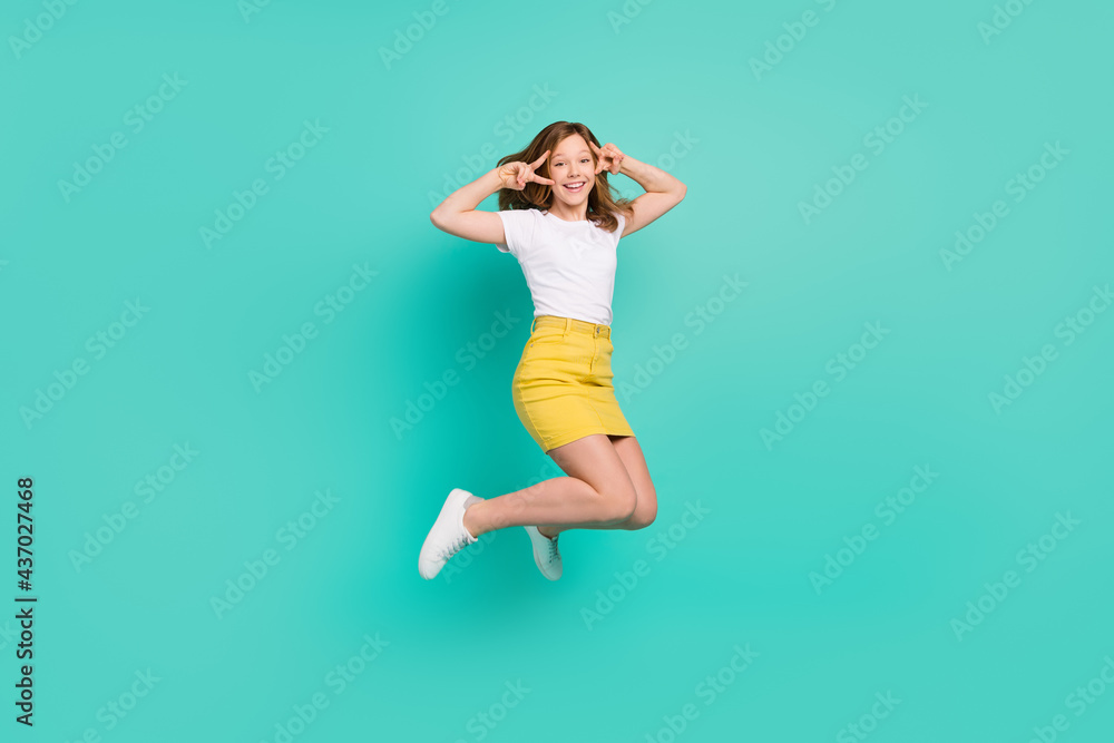 Full length body size photo schoolgirl jumping up showing v-sign ...