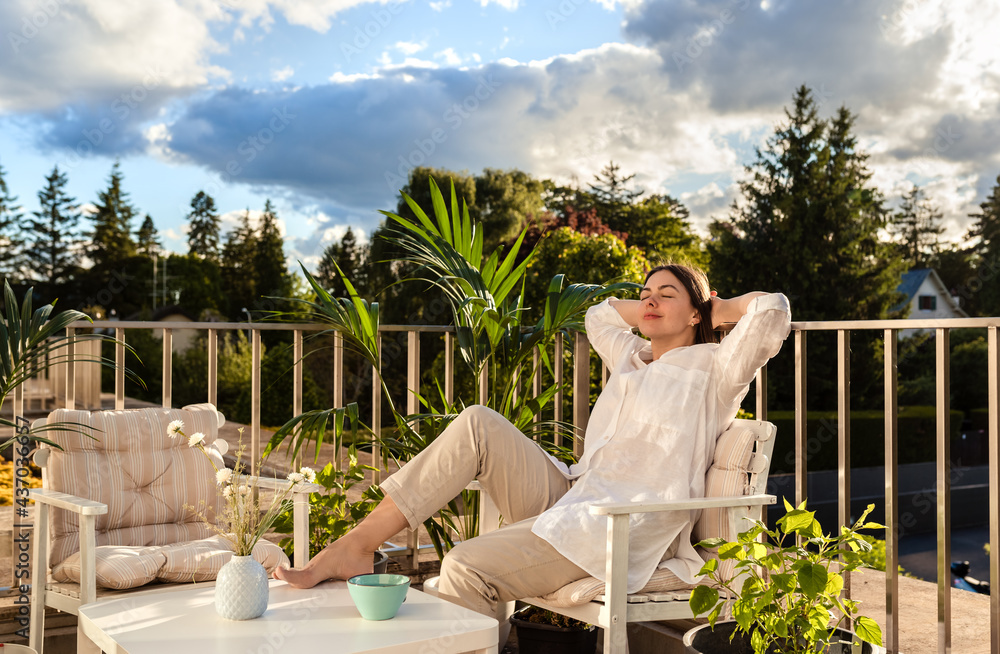 Beautiful young girl relaxing and enjoying sun while having tea ...