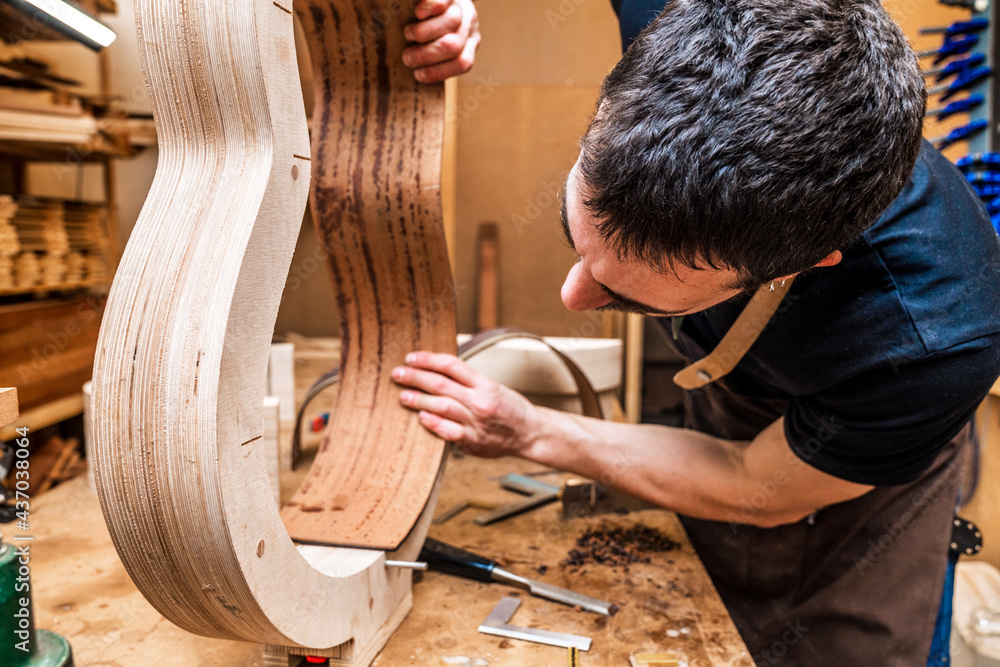 Luthier building guitar at table in workshop Stock Photo | Adobe Stock