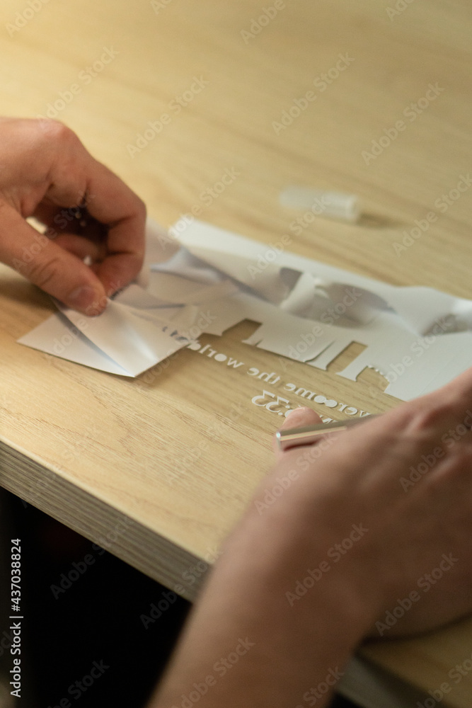 Crop unrecognizable person transferring cutout letters on transparent ...