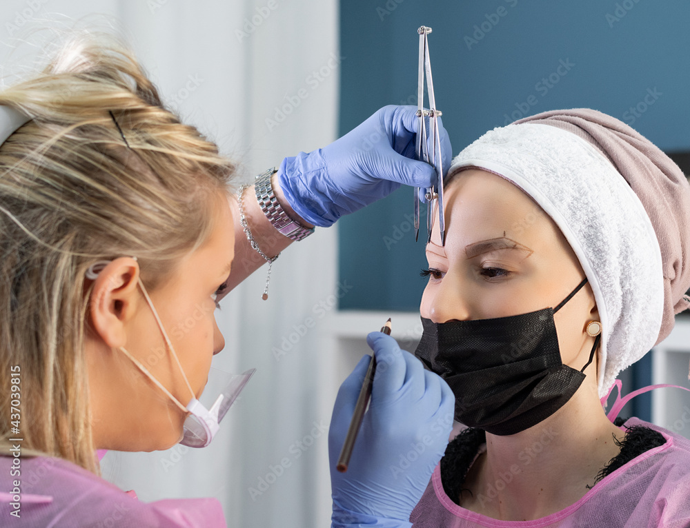 Side view of the hand of the master cosmetologist measures the ...