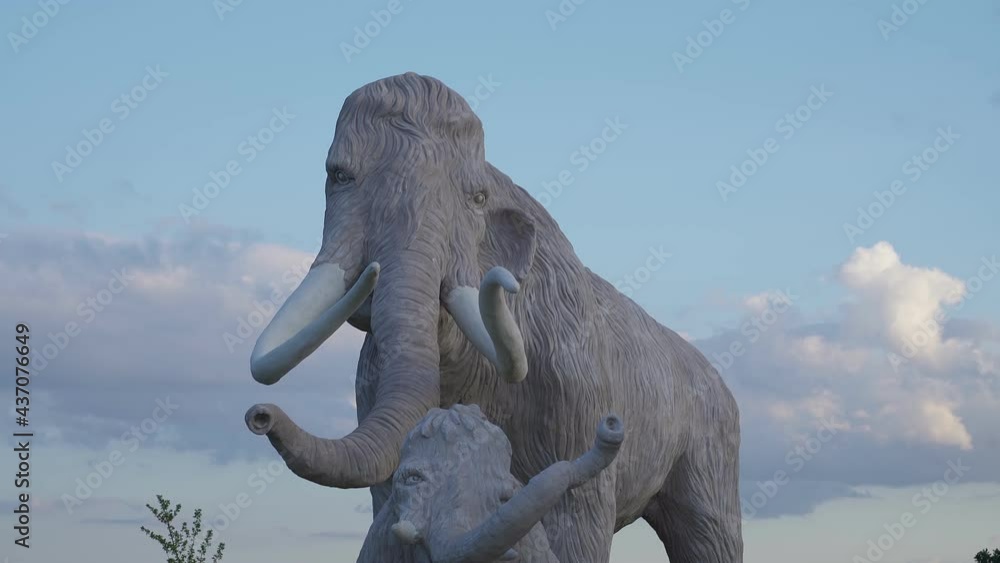 From below motion of huge sculptures of extinct mammoths outdoors ...
