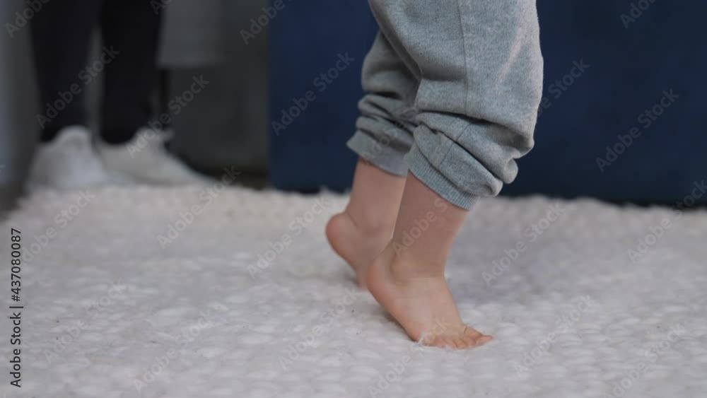 First steps. Kid learns to walk at home. Happy kid is taking first ...