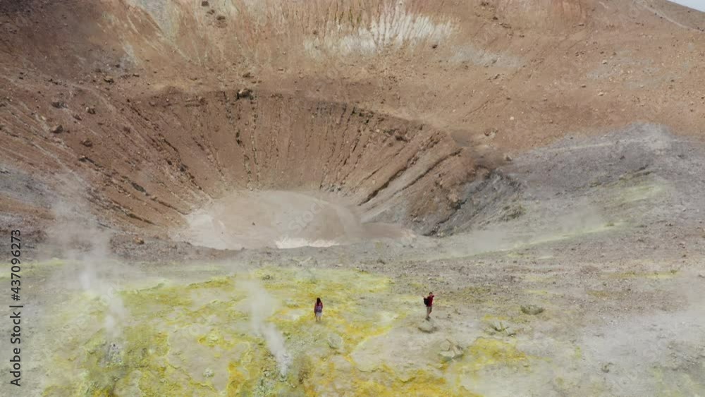 Male and female hikers traveling hiking on volcano and walking trough ...