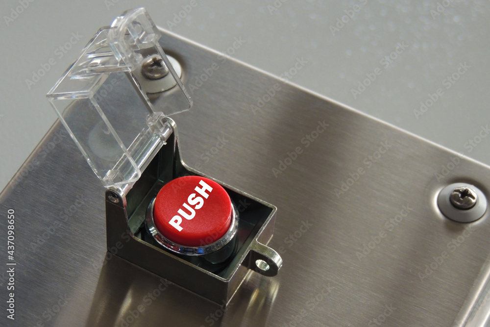 Foto de Round, red button with safety hood raised. The button is ...