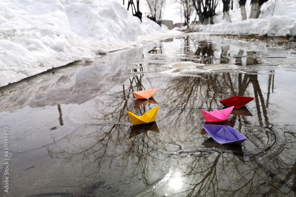 Paper origami. Ships yellow, blue, red, pink float on the water. Water ...