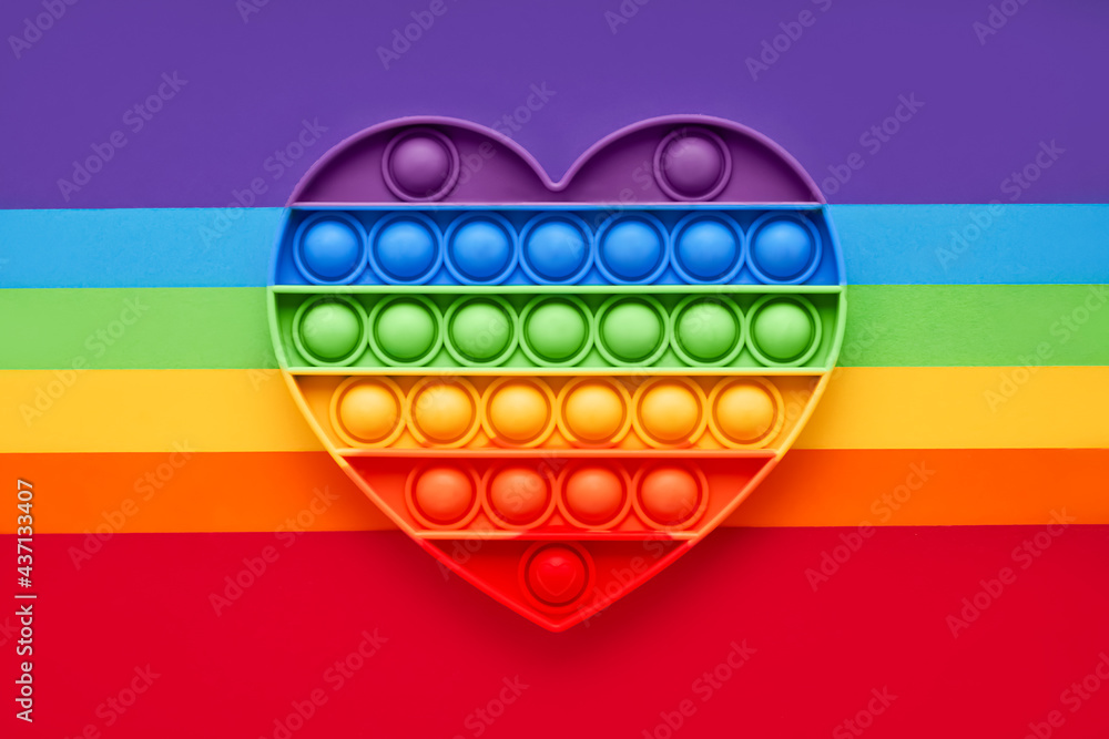 Colorful trendy Pop it fidgets toy on a rainbow background. Toy anti ...