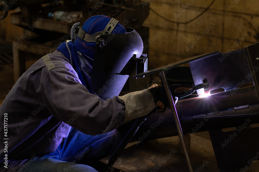 Skillful welders weld steel in the factory. Construction site metal ...